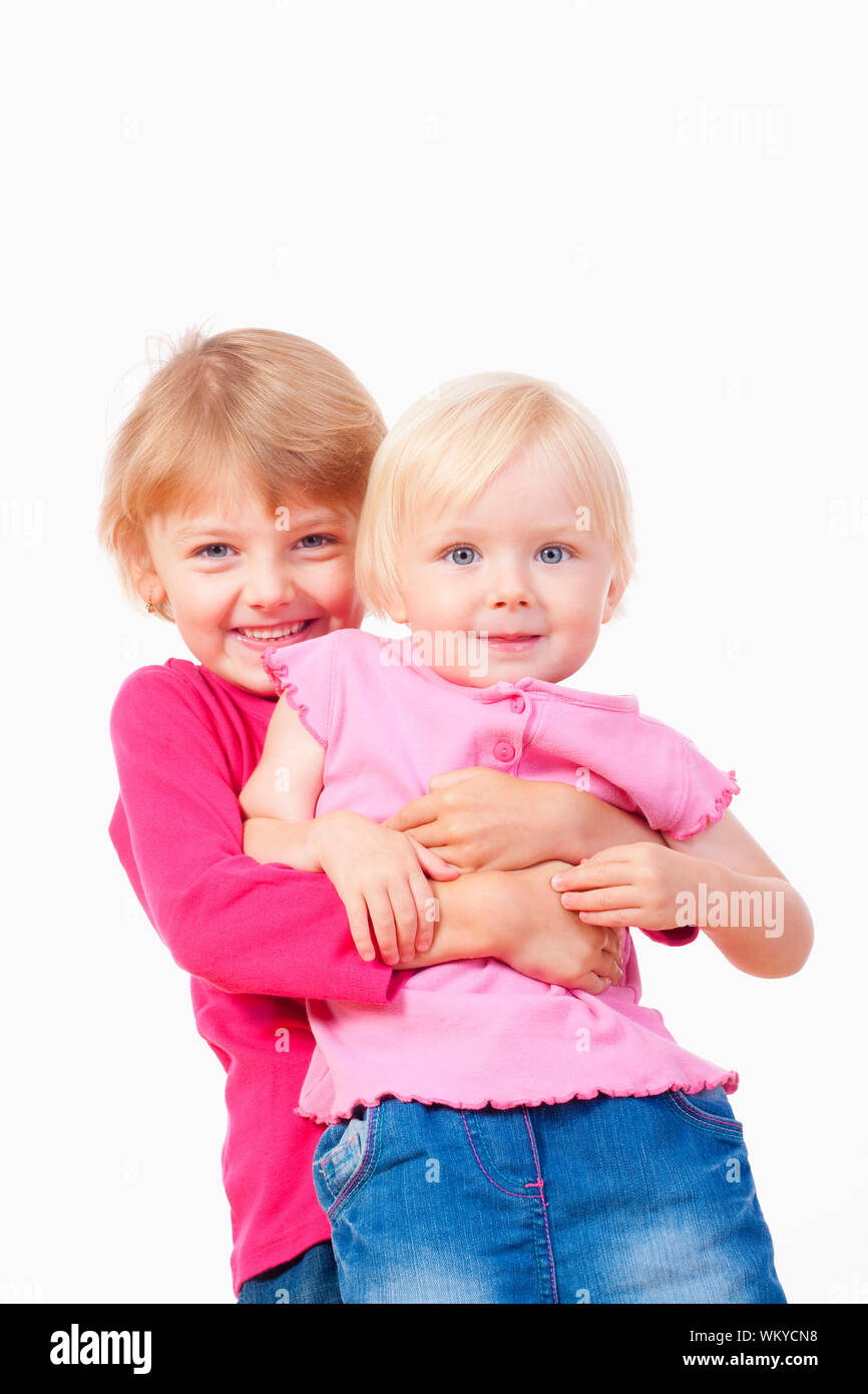 two sisters - older sister carrying the younger one, laughing ...