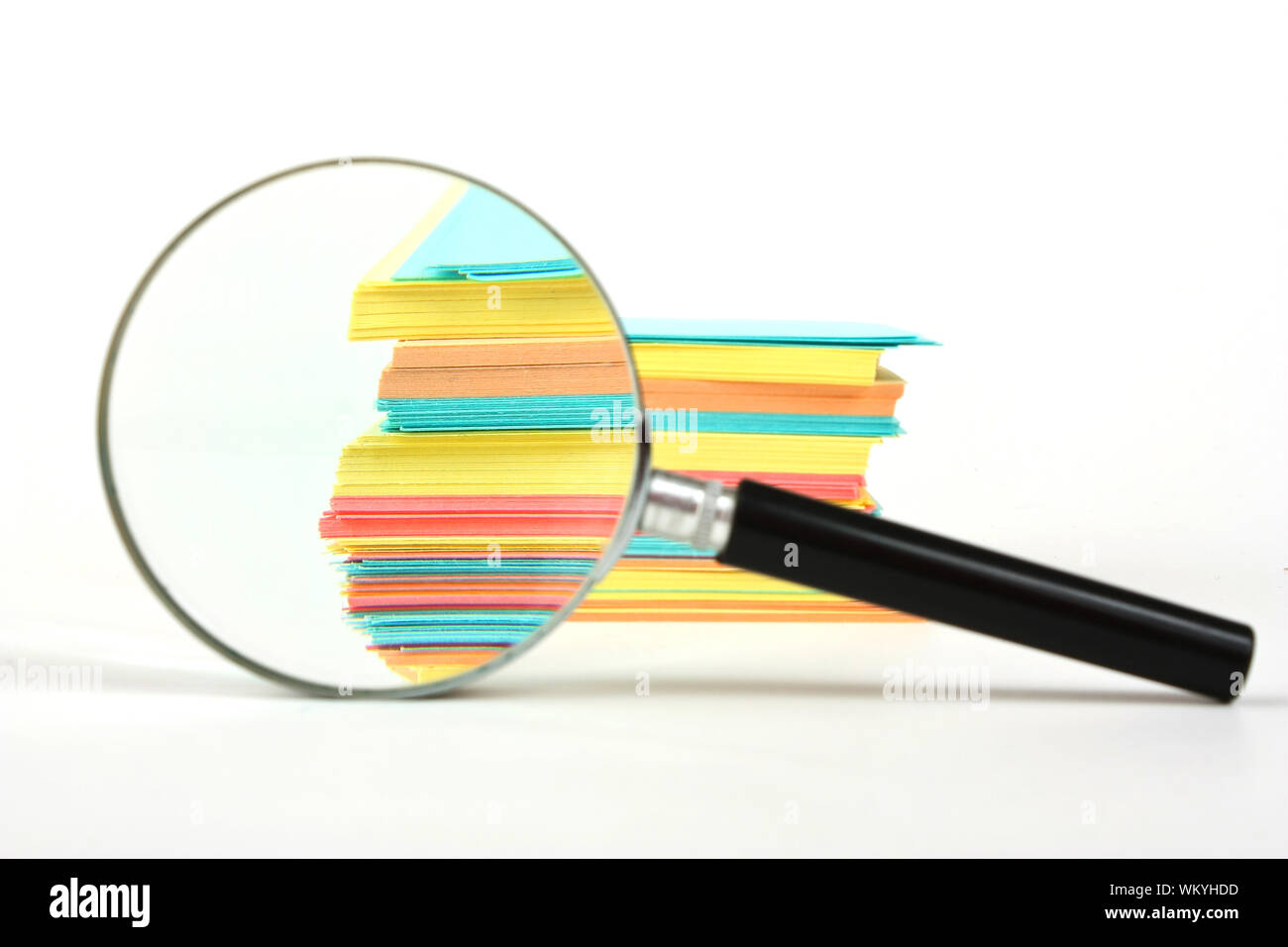Magnifier enlarges the stack of sheets of paper Stock Photo - Alamy