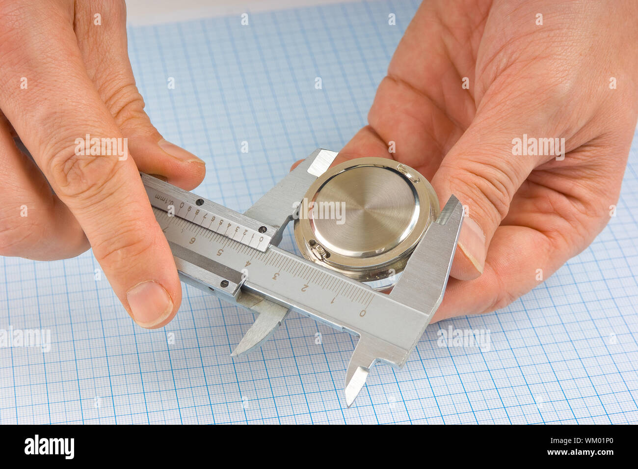 caliper measures the detail on the background of graph paper Stock ...