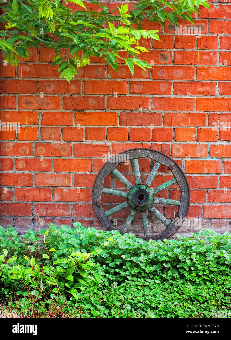 old wagon wheel against the brick wall Stock Photo - Alamy