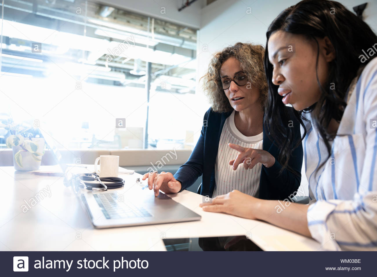 Business manager using laptop with colleague Stock Photo - Alamy