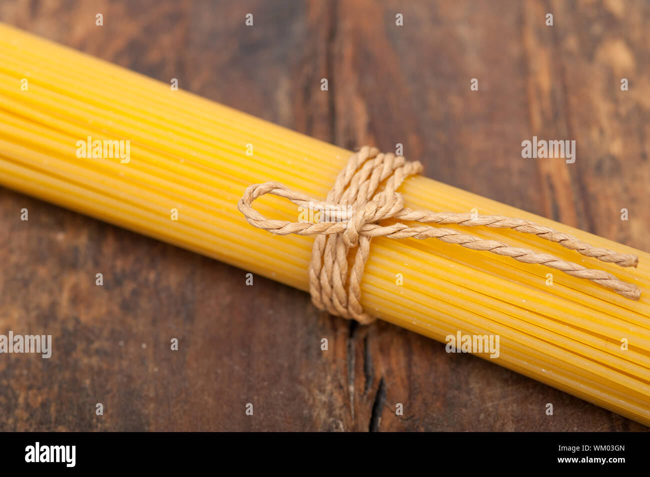 Italian pasta spaghetti tied with a rope on a rustic table Stock Photo ...