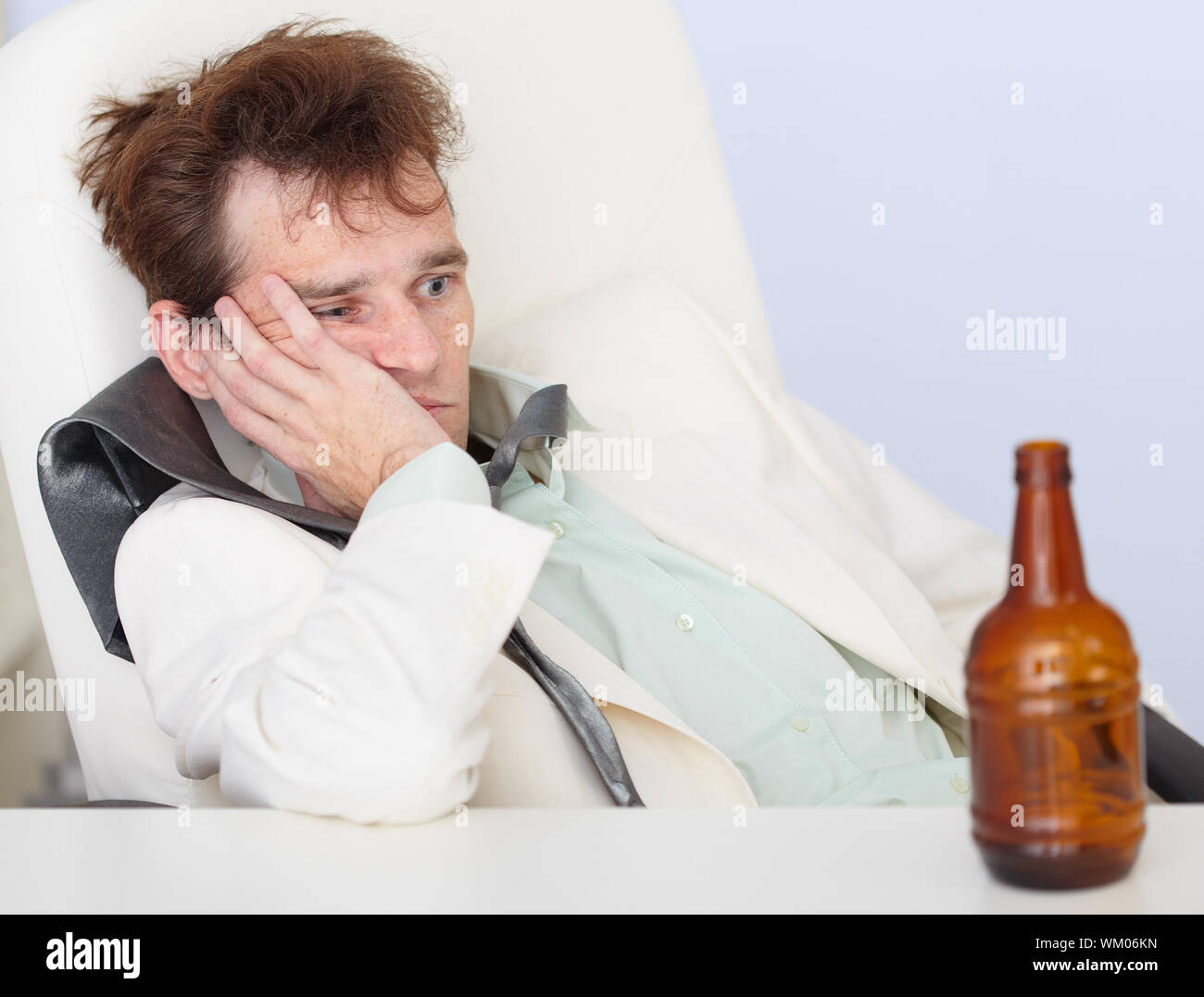 The young businessman sits sad with an empty bottle Stock Photo - Alamy