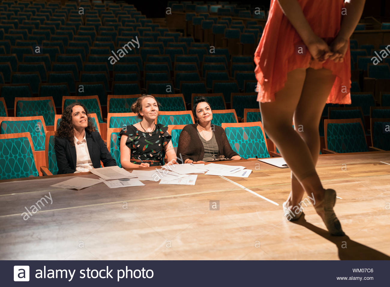 Female judges watching dancer on stage in auditorium Stock Photo - Alamy
