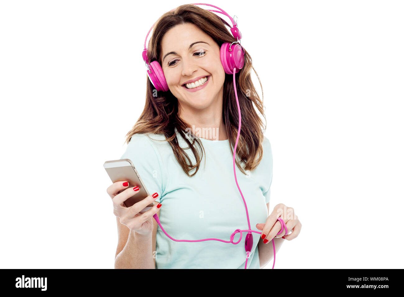 Smiling woman using mobile phone listening to music Stock Photo - Alamy