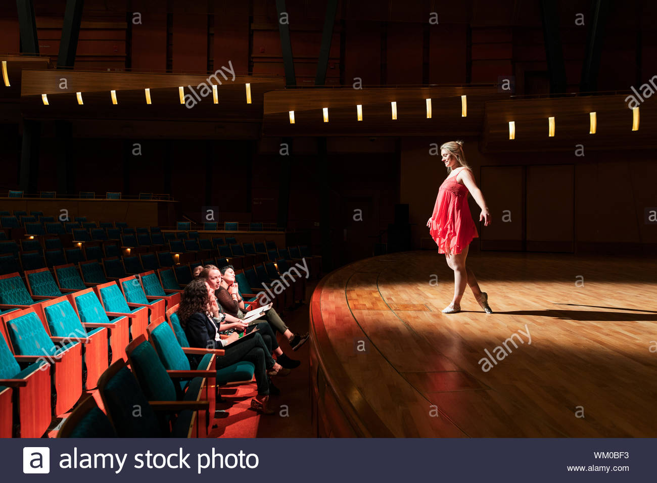 Female dancer performing for judges on stage in auditorium Stock Photo ...