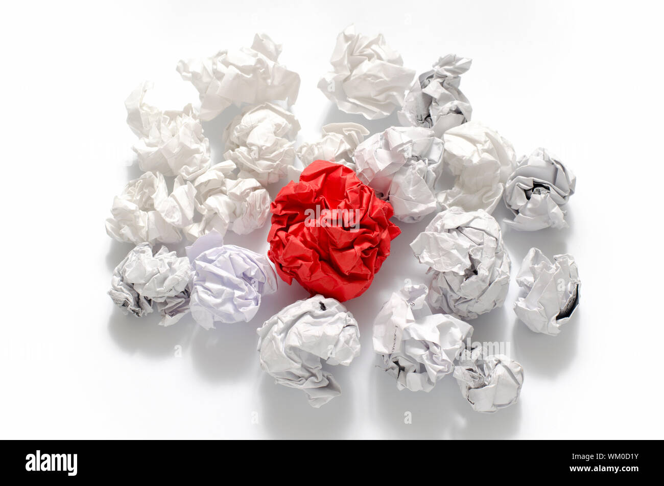 white crumpled paper ball and different red crumpled paper ball on a ...