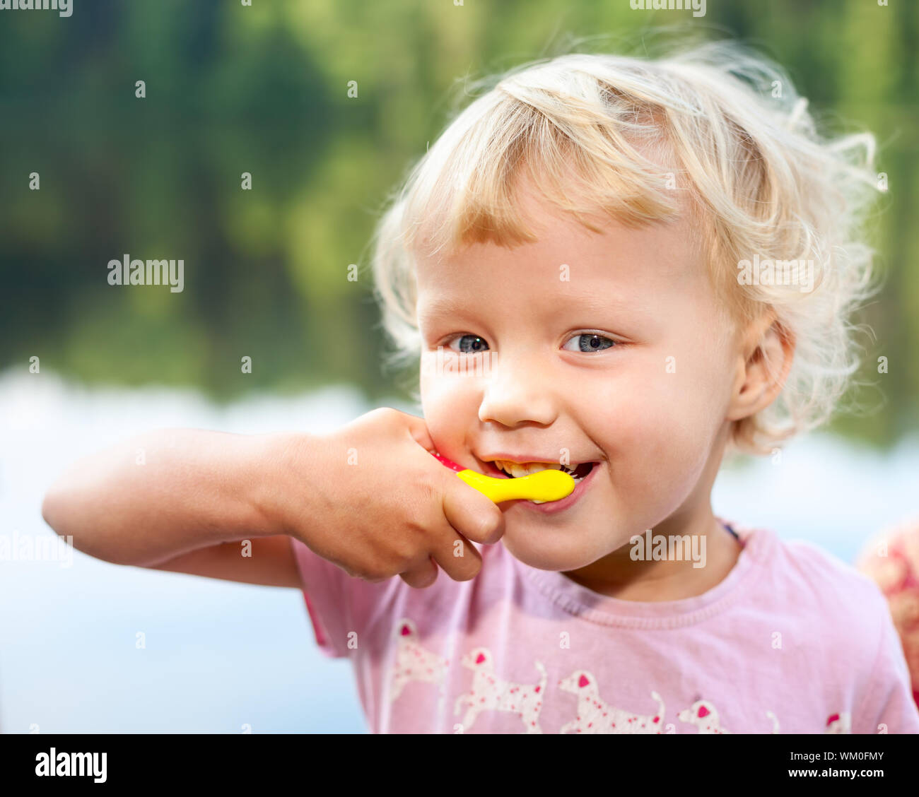 Portrait of cute little girl brushing teeth outdoor Stock Photo - Alamy