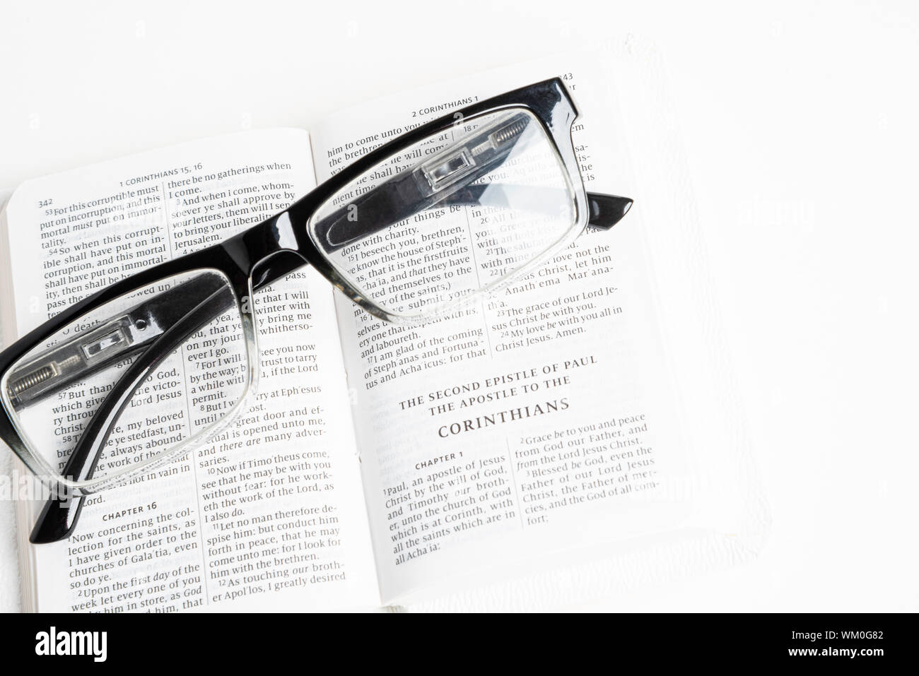 An open white portable pocket bible with a pair of clear reading ...