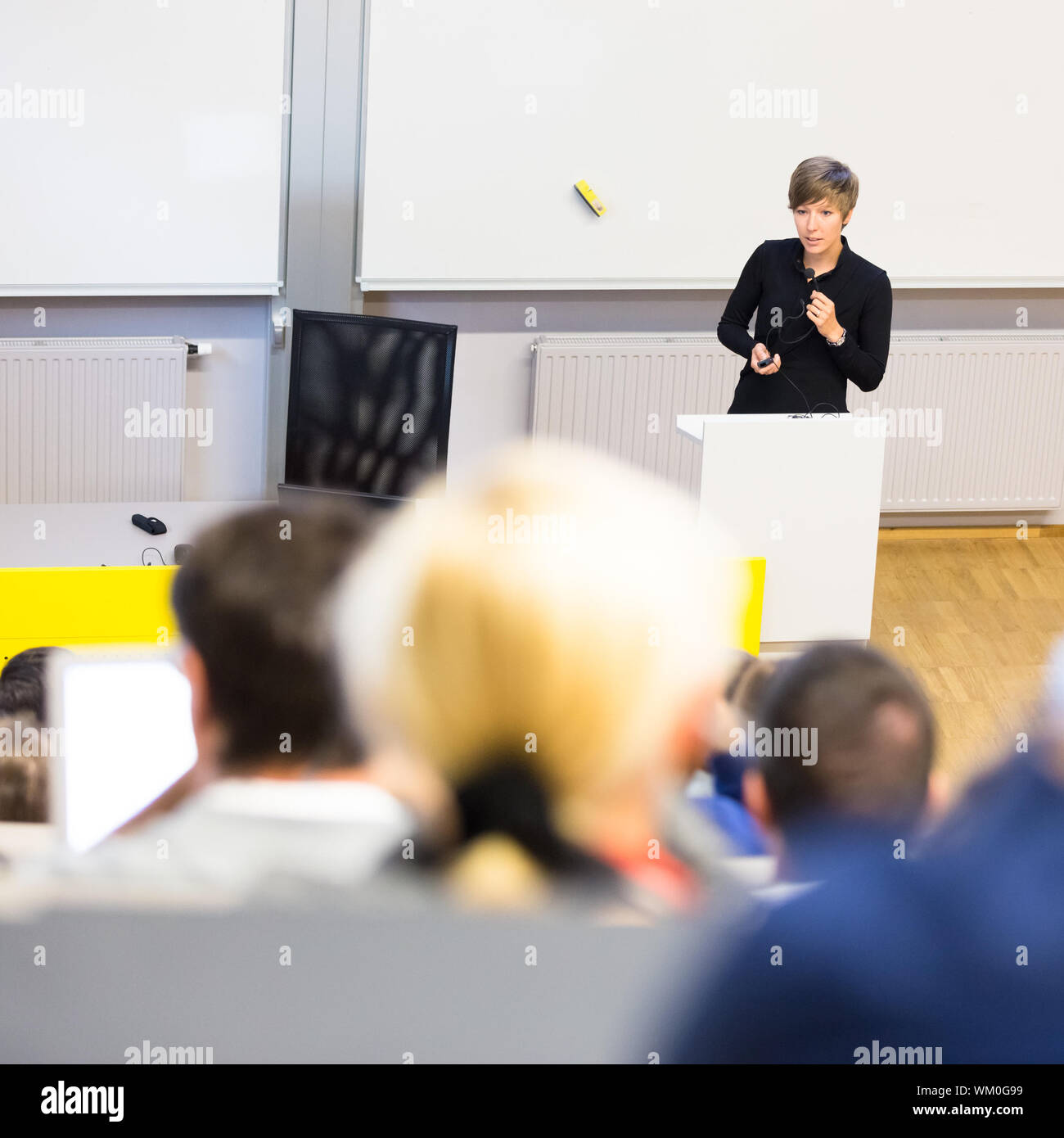 Speaker giving presentation in lecture hall at university. Participants ... Speaker giving presentation in lecture hall at university. Participants ...