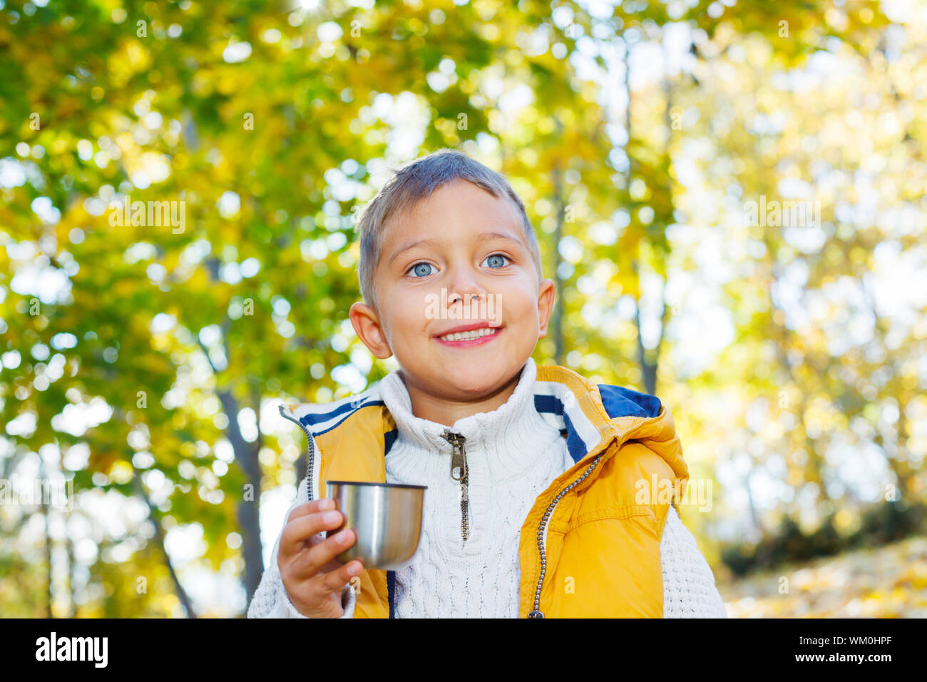 Portrait of Adorable cute boy resting and drinking tea from a thermos ...
