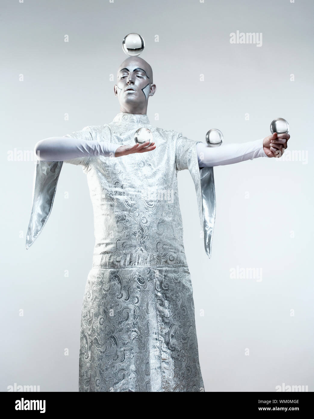 Magician with Glass Balls in Stage Makeup and Costume Stock Photo - Alamy