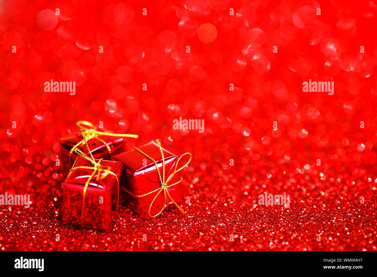 Decorated red holiday gifts on glitter background Stock Photo - Alamy