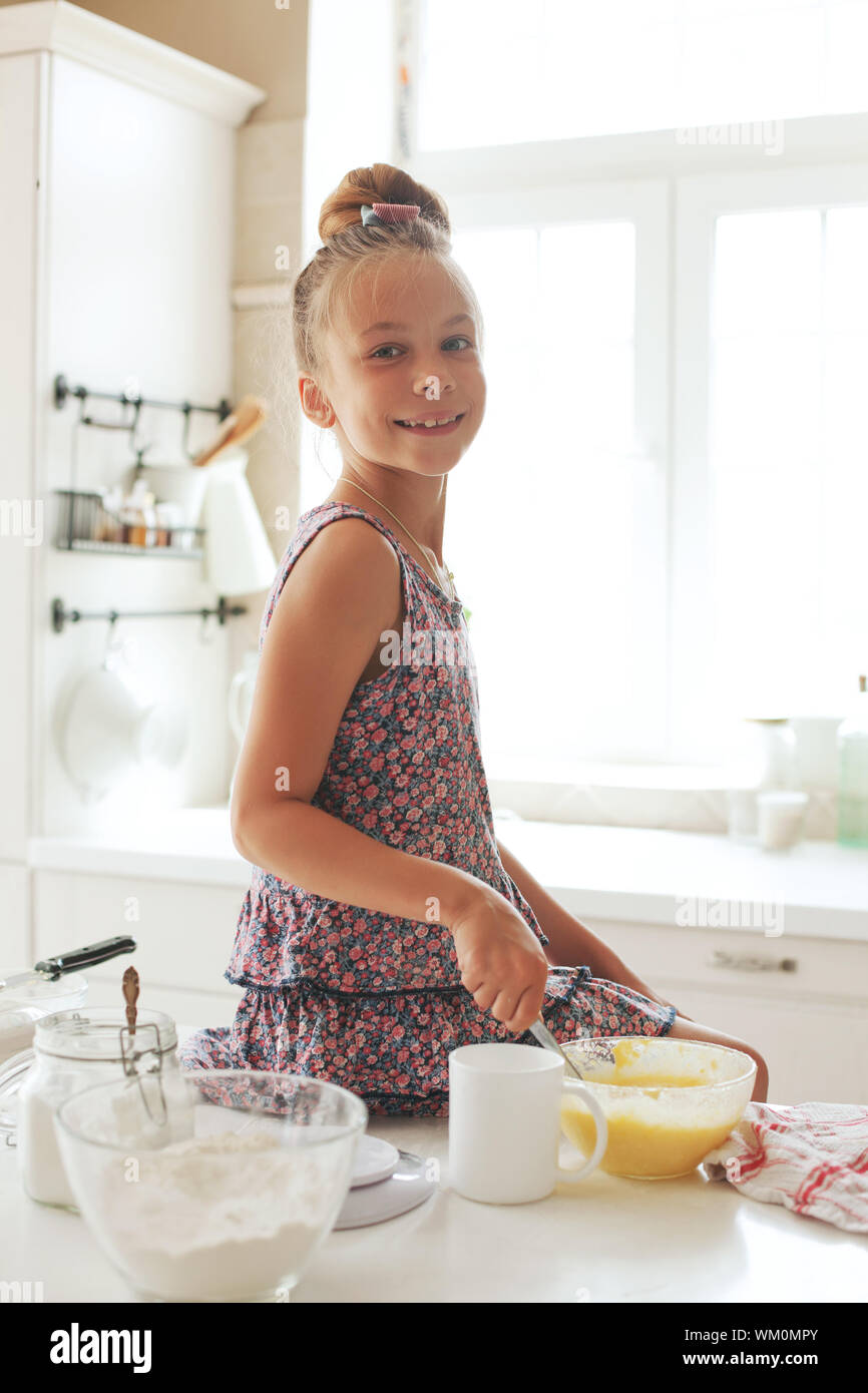 7 years old school girl cooking at the kitchen, casual lifestyle photo ...