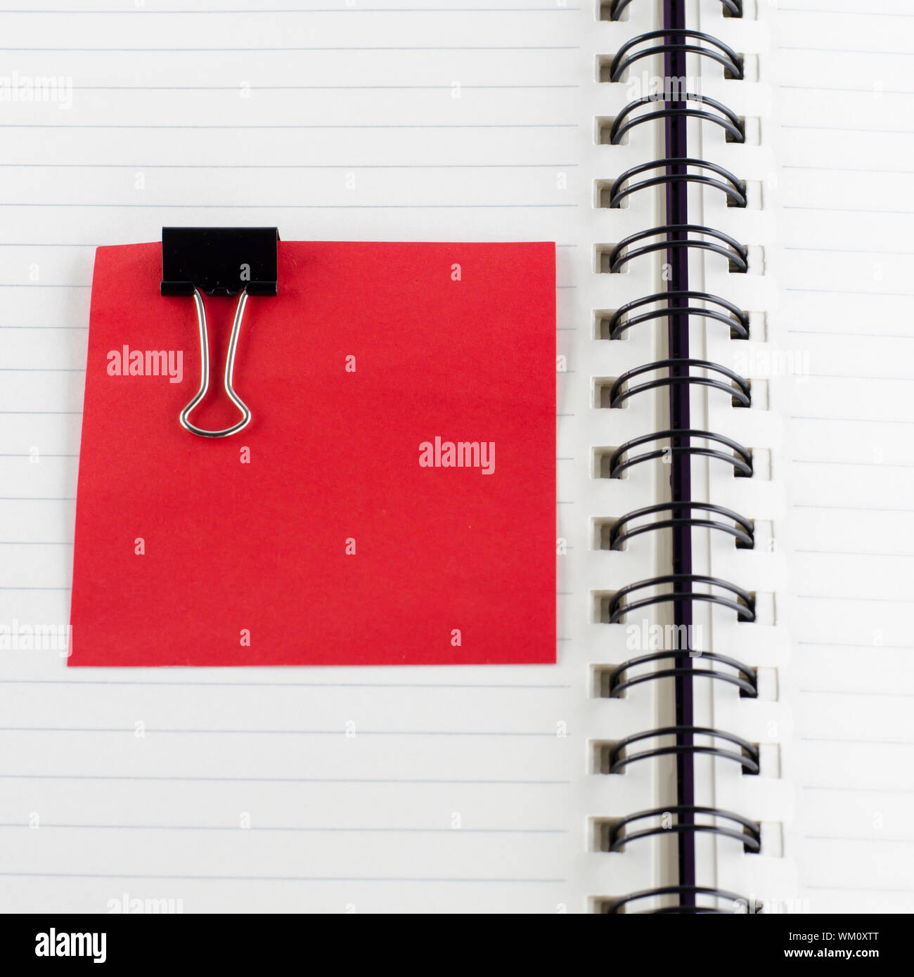 red paper note with black clip on notebook Stock Photo - Alamy
