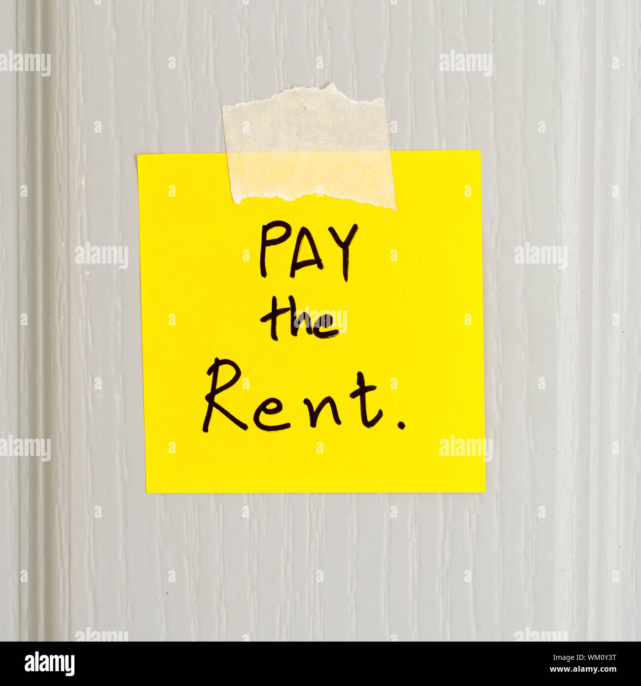 sticky note write a message pay the rent on wood door background Stock ...