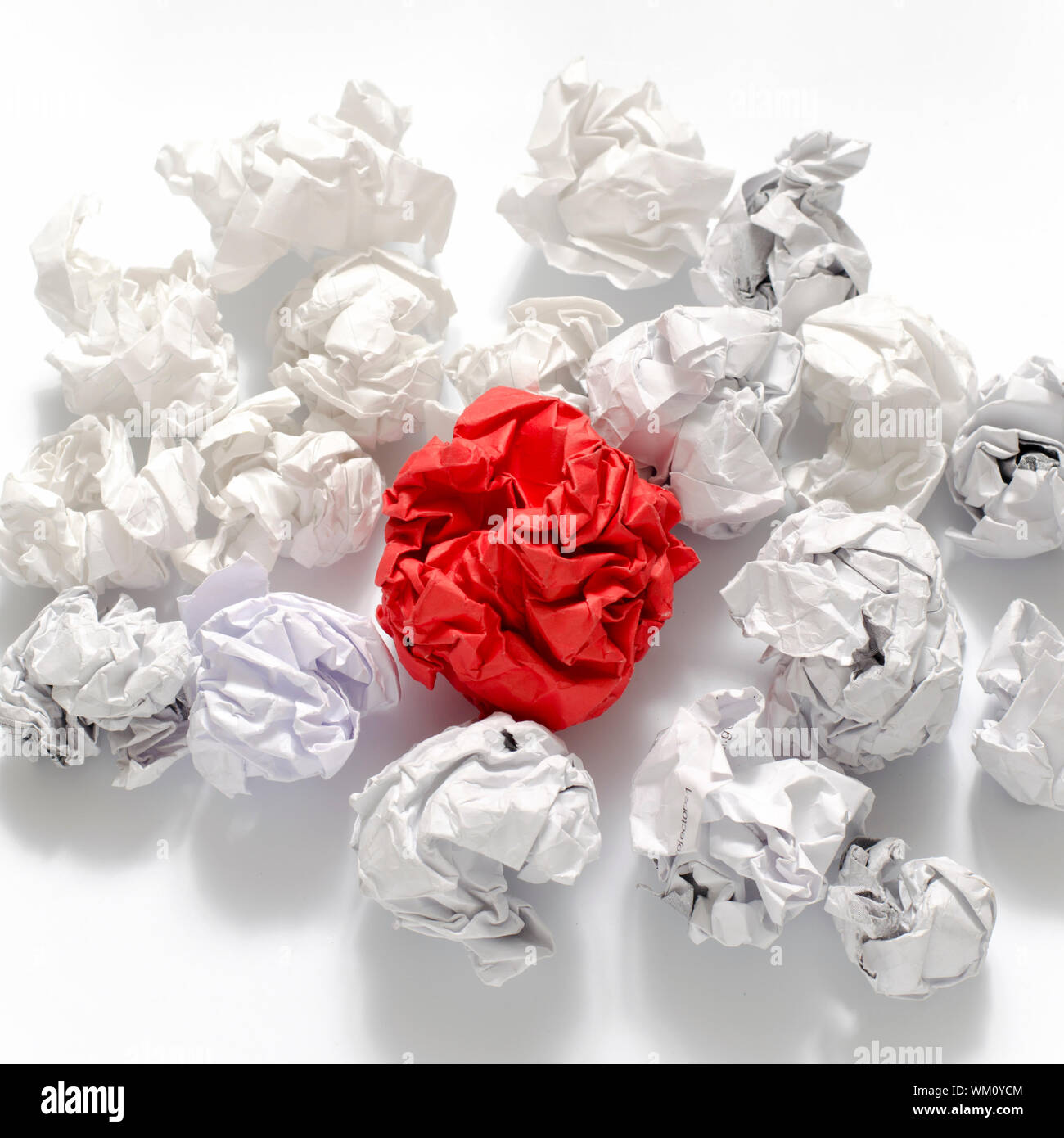 white crumpled paper ball and different red crumpled paper ball on a ...