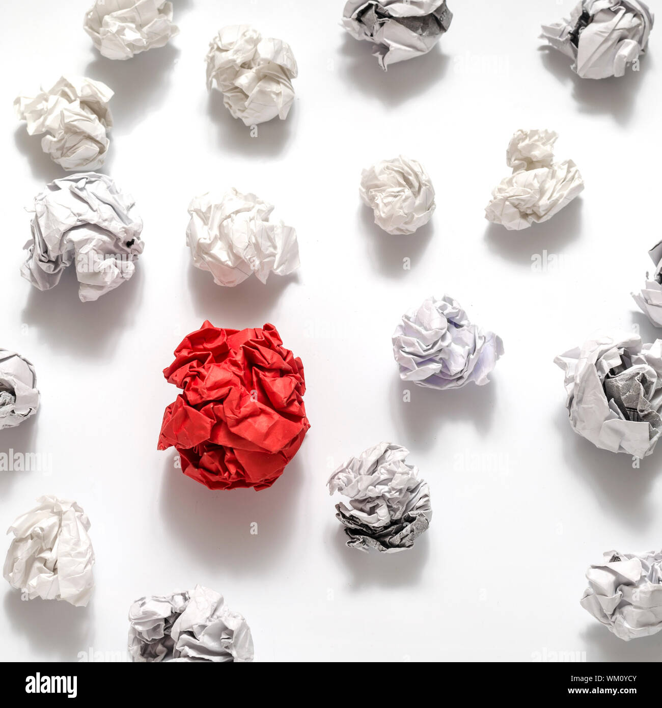 white crumpled paper ball and different red crumpled paper ball on a ...