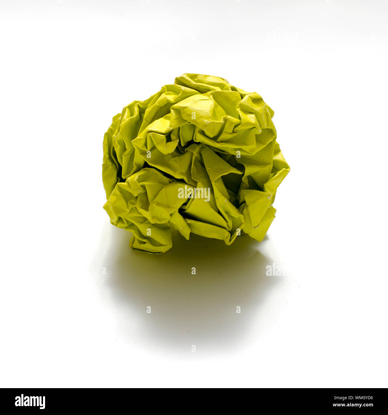 yellow color crumpled paper ball on a white background Stock Photo - Alamy
