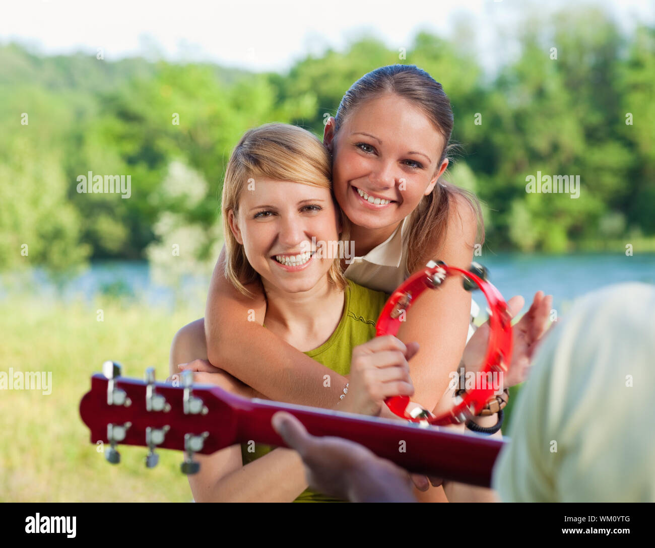 three friends playing guitar and tambourine outdoors Stock Photo - Alamy