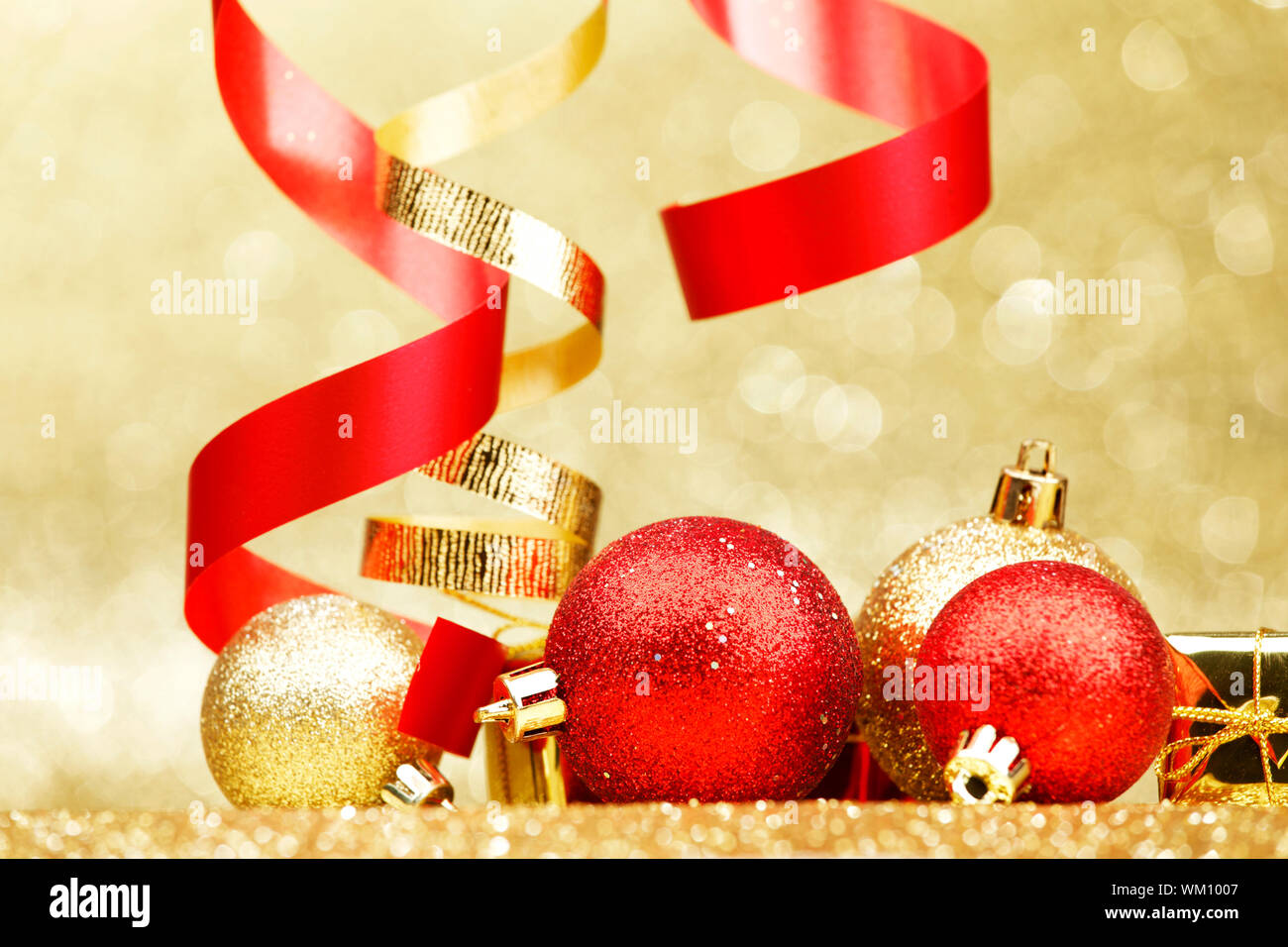 Colorful decorative curling ribbons and balls over glitter background ...