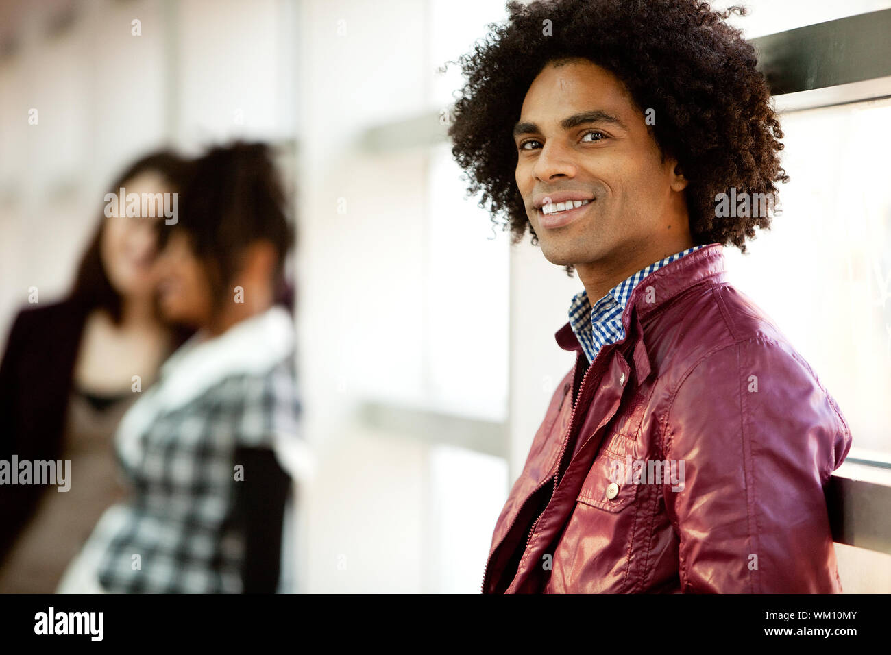An African American male with two women talking in the background Stock ...