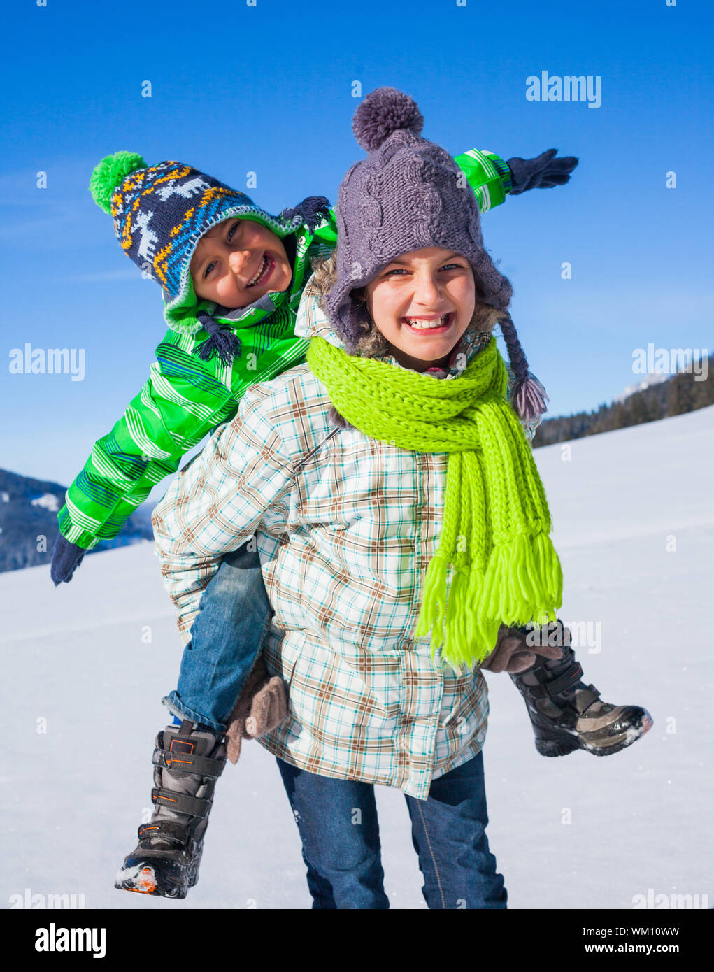Two happy kids playing winter on the snow in Alps Stock Photo - Alamy