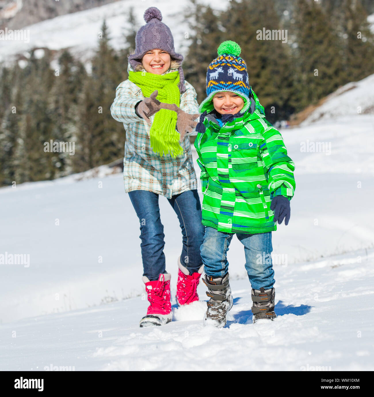 Two happy kids playing winter on the snow in Alps Stock Photo - Alamy