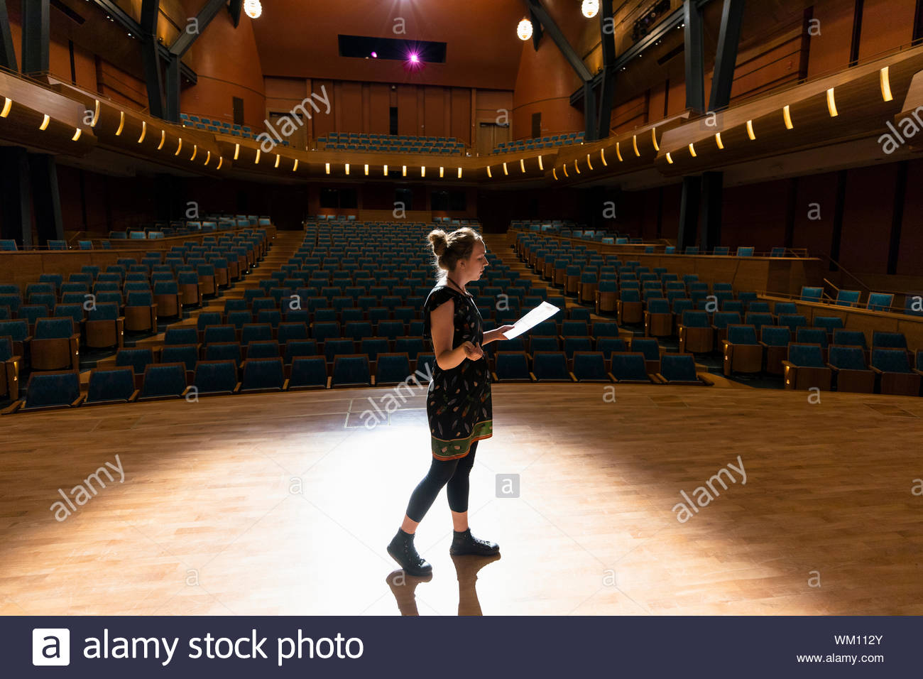 Woman speaking on stage in spotlight hi-res stock photography and ...