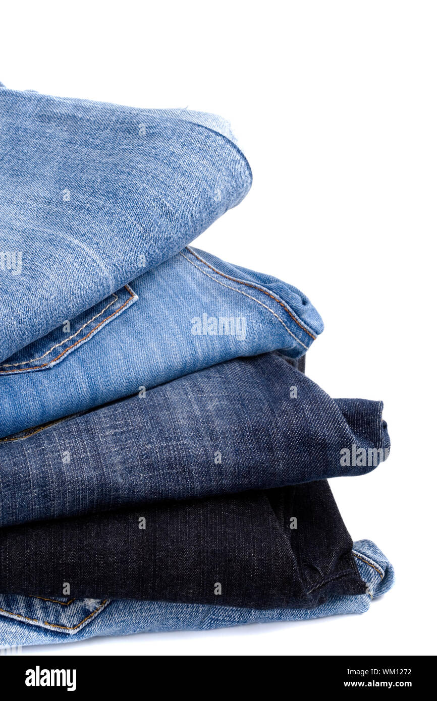 stack of blue jeans closeup on white background Stock Photo - Alamy