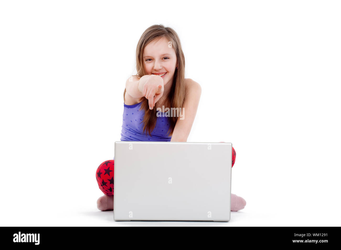 girl sitting on the floor with laptop pointing at camera smiling Stock ...