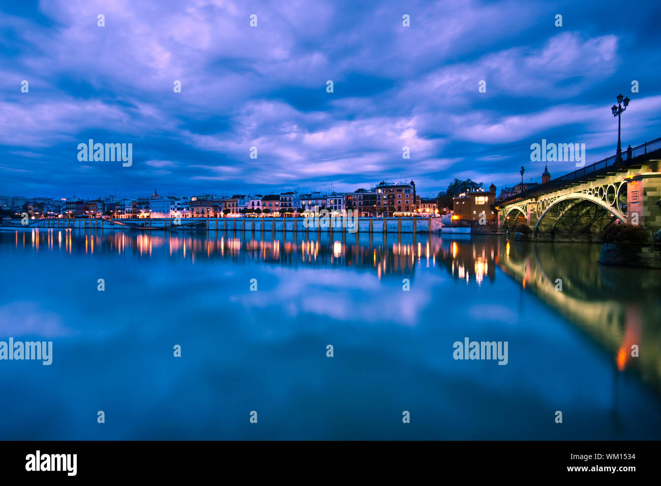 Dramatic panorama of Seville riverside at down and the Triana Bridge ...