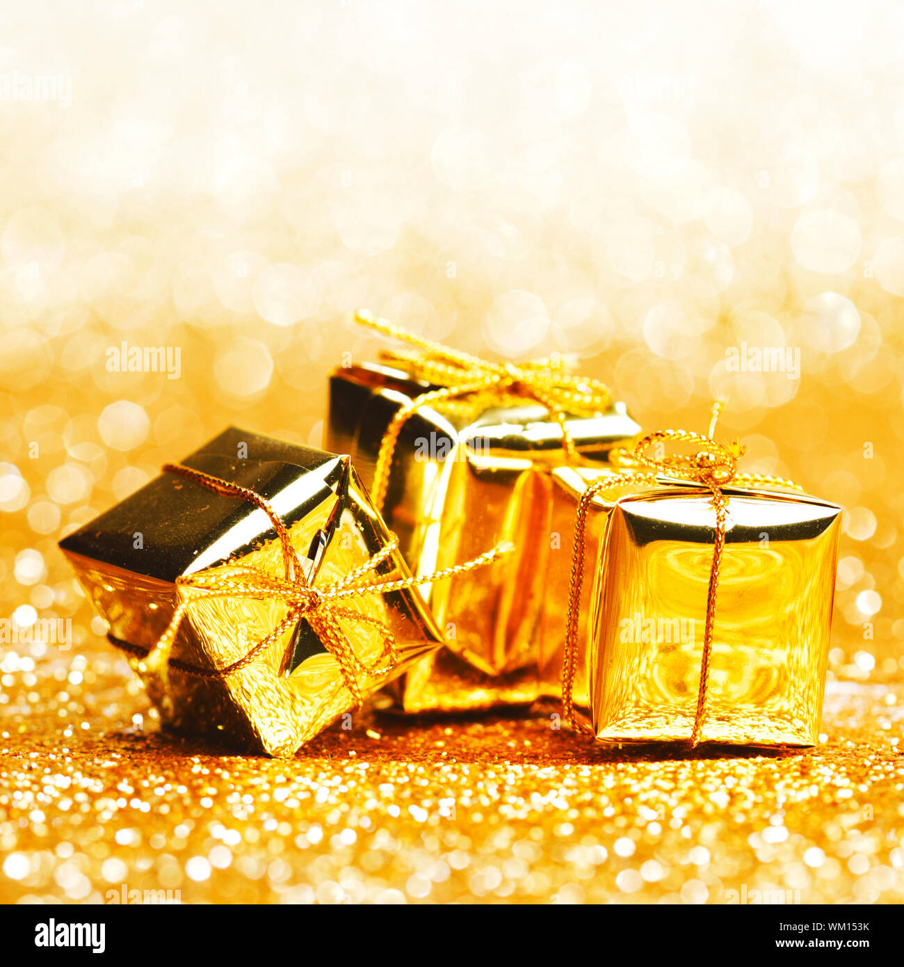 Decorative golden boxes with holiday gifts on shiny glitter background ...