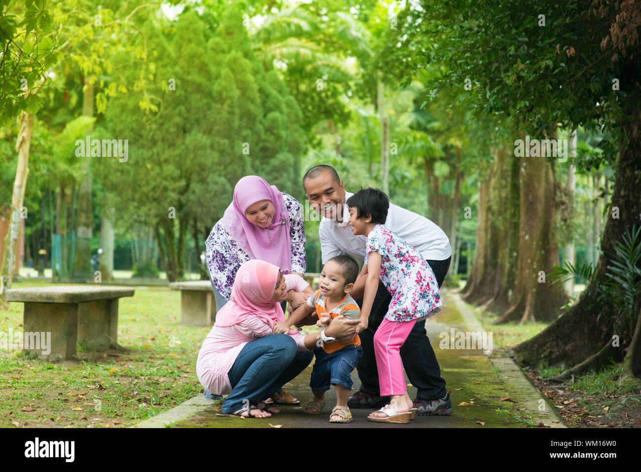 Family playing at outdoor garden park. Happy Southeast Asian people ...