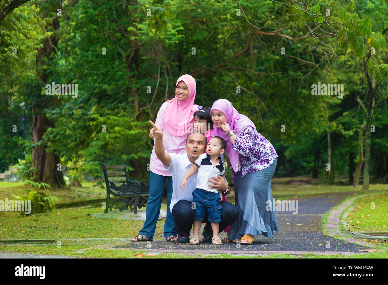 Happy Southeast Asian family outdoor lifestyle at nature green park ...