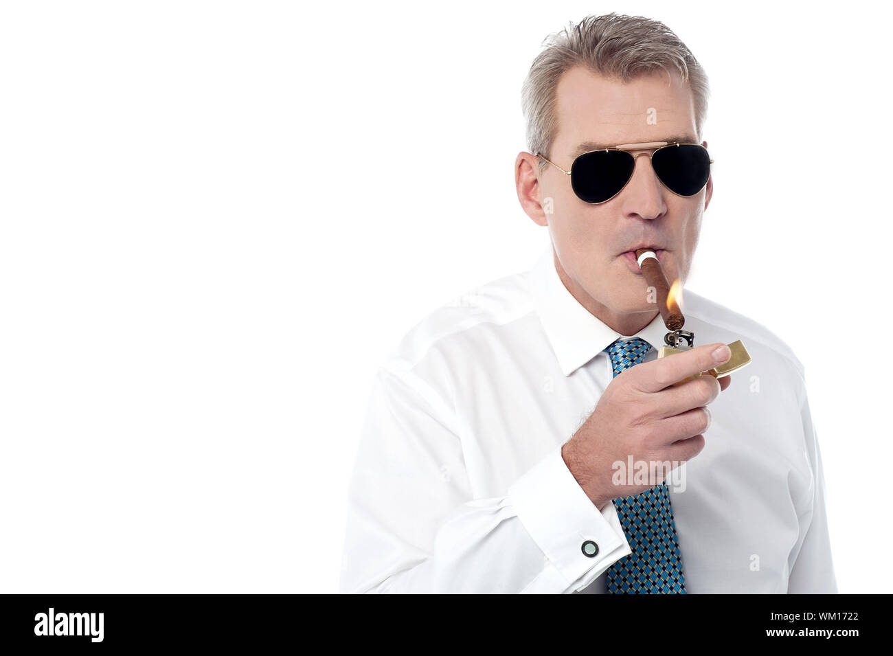 Senior businessman lighting up a cigar with lighter Stock Photo - Alamy