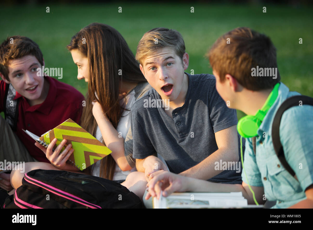 Surprised young student with group of friends outdoors Stock Photo - Alamy