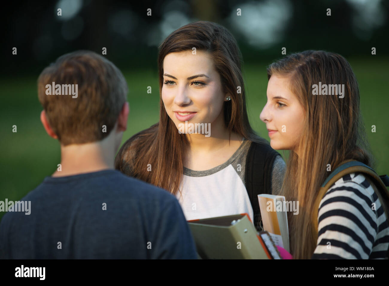 Group of three young Caucasian students talking outdoors Stock Photo ...