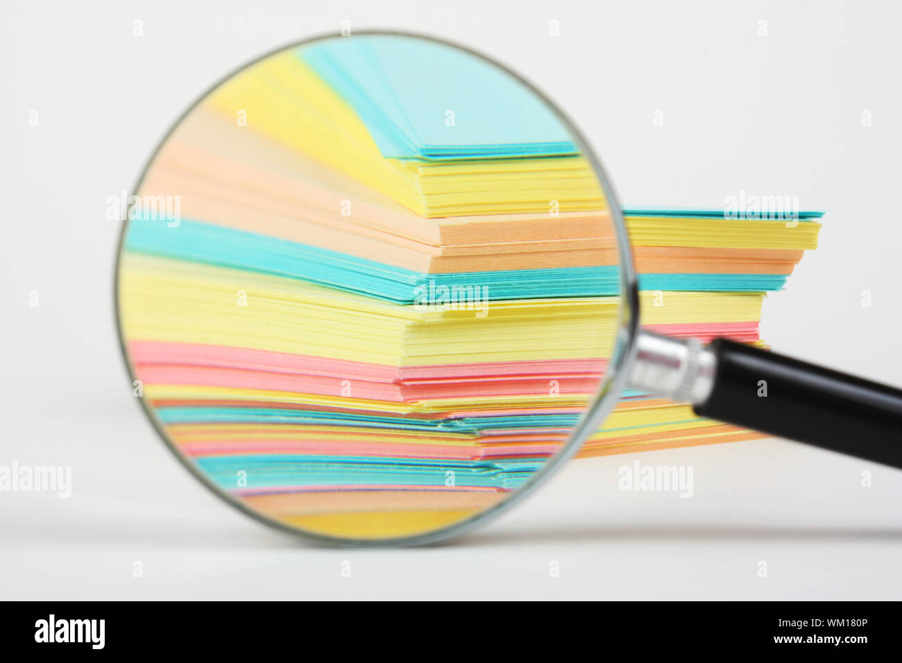 Magnifier enlarges the stack of sheets of paper Stock Photo - Alamy