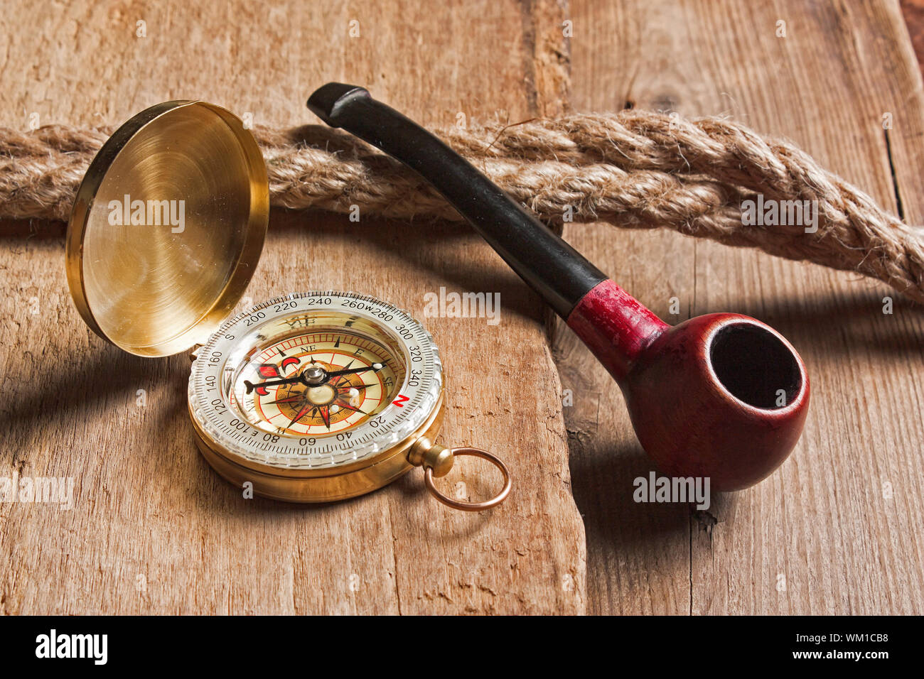 Compass and a pipe with a rope on the background of the old board Stock ...