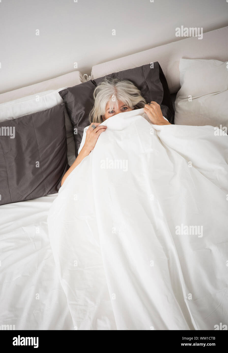 Afraid woman alone in the bedroom Stock Photo - Alamy