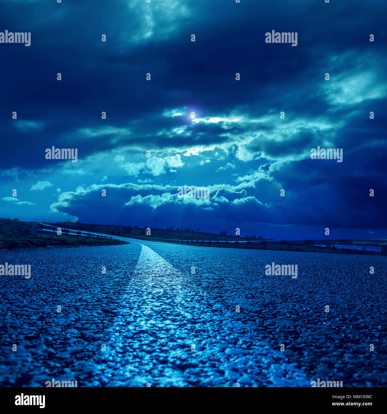 low dramatic clouds over asphalt road in dark blue moonlight Stock ...