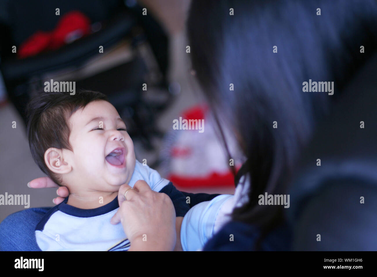 Mother tickling her baby Stock Photo - Alamy