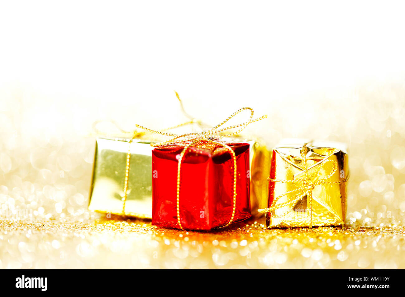 Decorative red and gold boxes with holiday gifts on shiny glitter ...