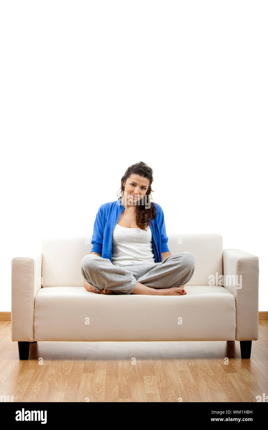 Beautiful young woman relaxing on the couch over a white background ...