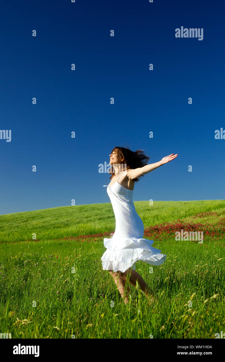Beautiful happy young woman dancing on the field Stock Photo - Alamy