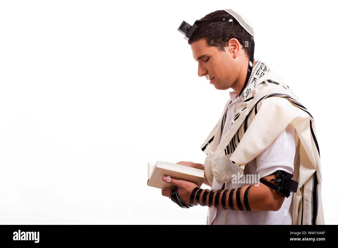 Side view of young jewish man with book on white isolated background ...