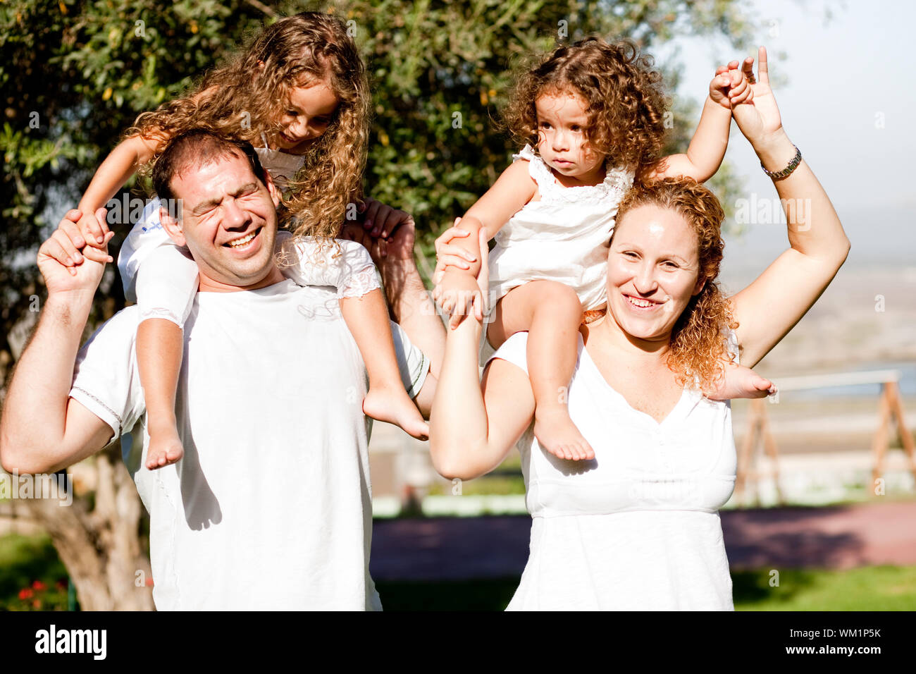 Happy family having fun and giving shoulder rides Stock Photo - Alamy