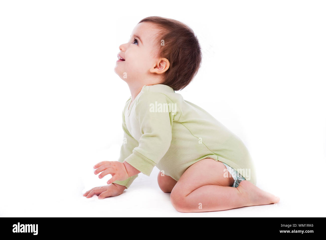Side pose of baby sitting and looking up in white background Stock ...