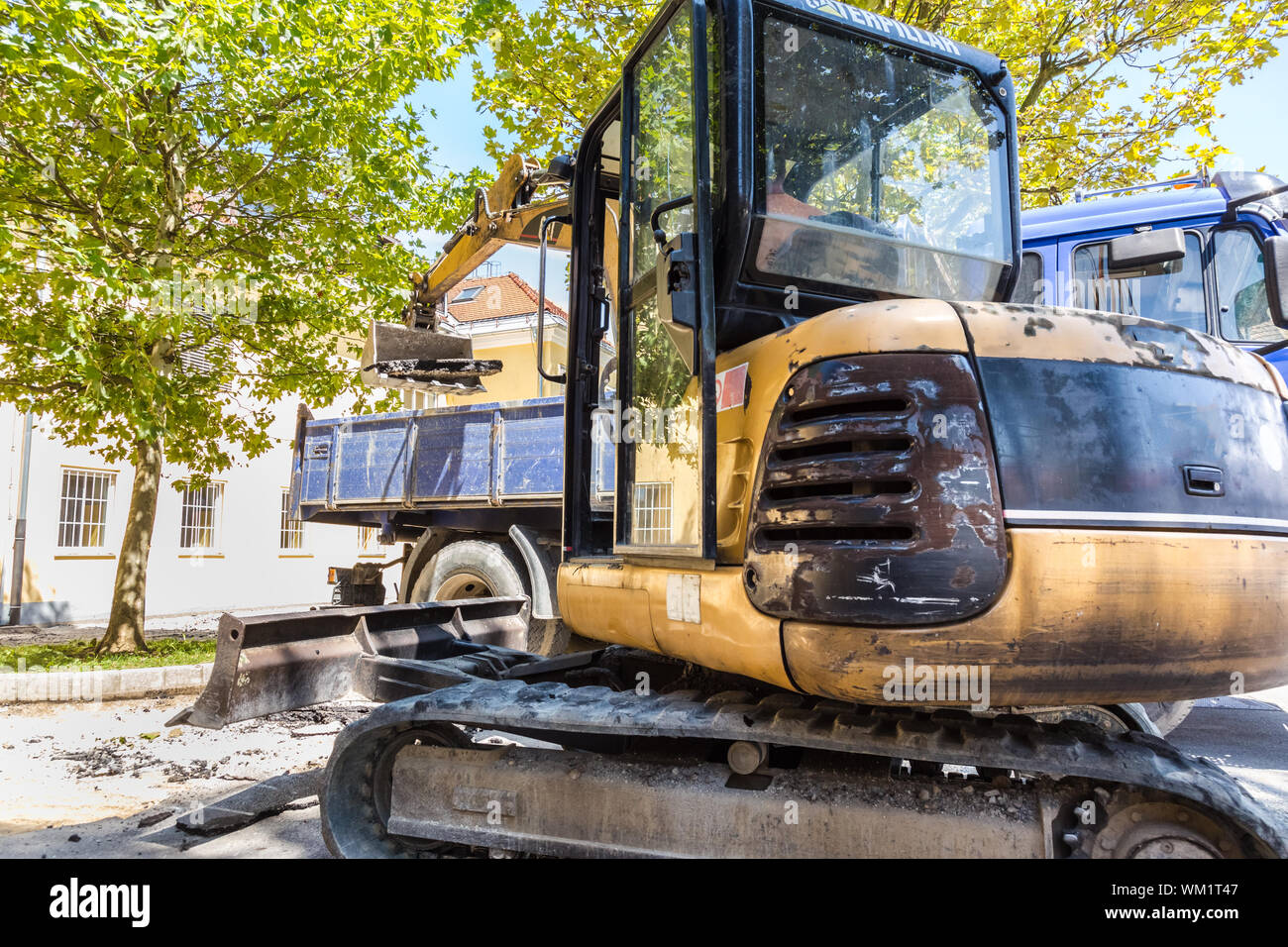 Excavator loading dumper truck Stock Photo - Alamy